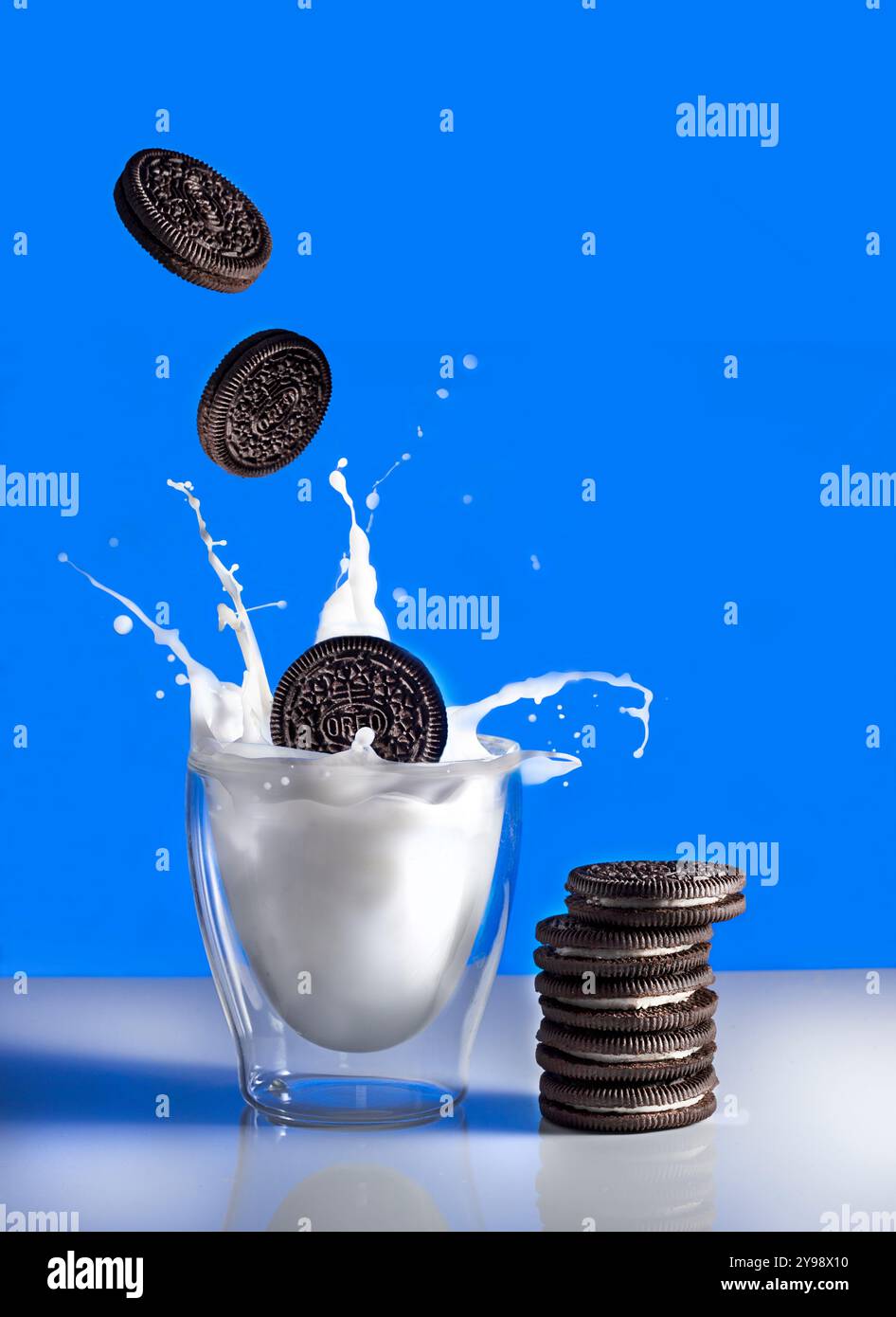 Oreo biscuits splashing into glass of milk and frozen in time by high ...