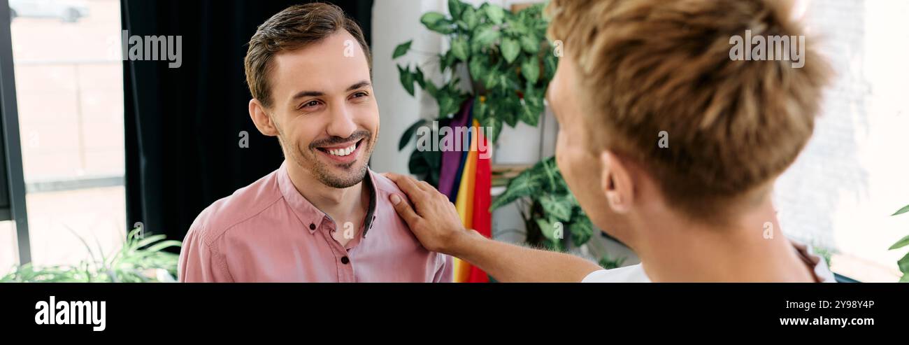 Two men share a warm smile, enjoying a playful interaction in a bright ...