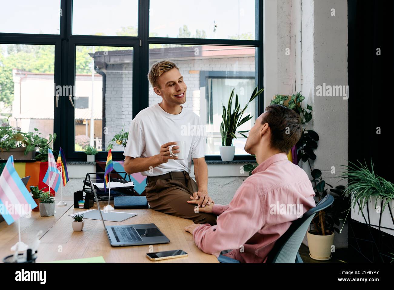 Two men enjoy a warm conversation while sipping coffee in a lively ...