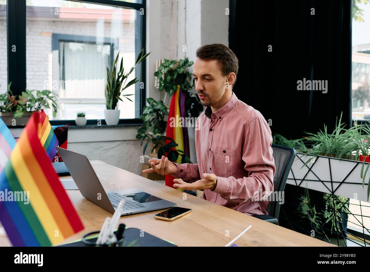 Good looking man working in office surrounded by colorful pride flags ...