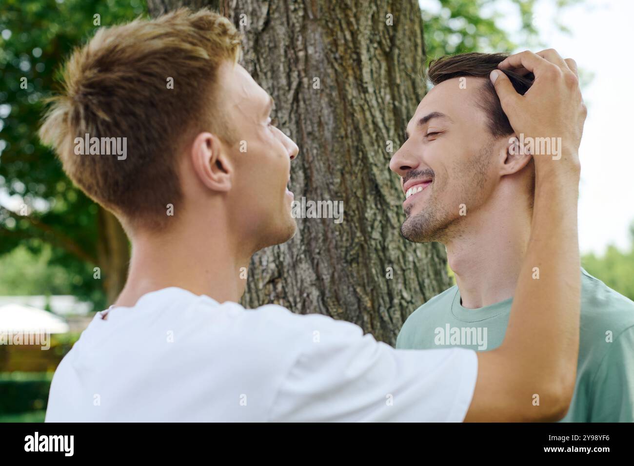 Two joyful men embrace while sharing a heartfelt smile in a vibrant ...