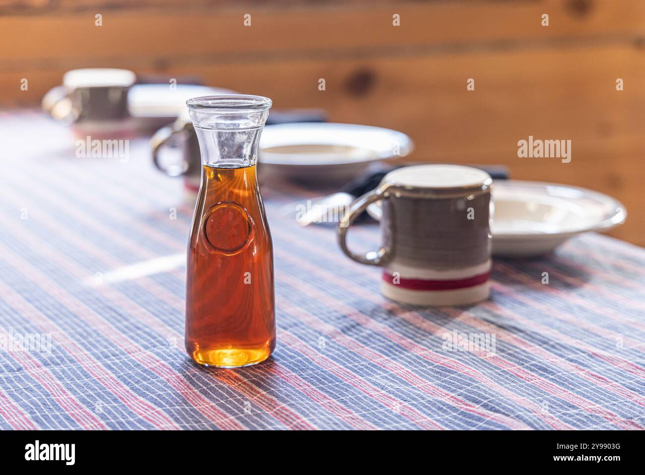Maple syrup in glass bottle is focal point of rustic breakfast table ...