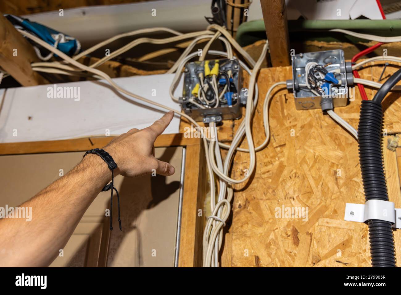 Electrician is pointing at an electrical box with exposed wires during ...