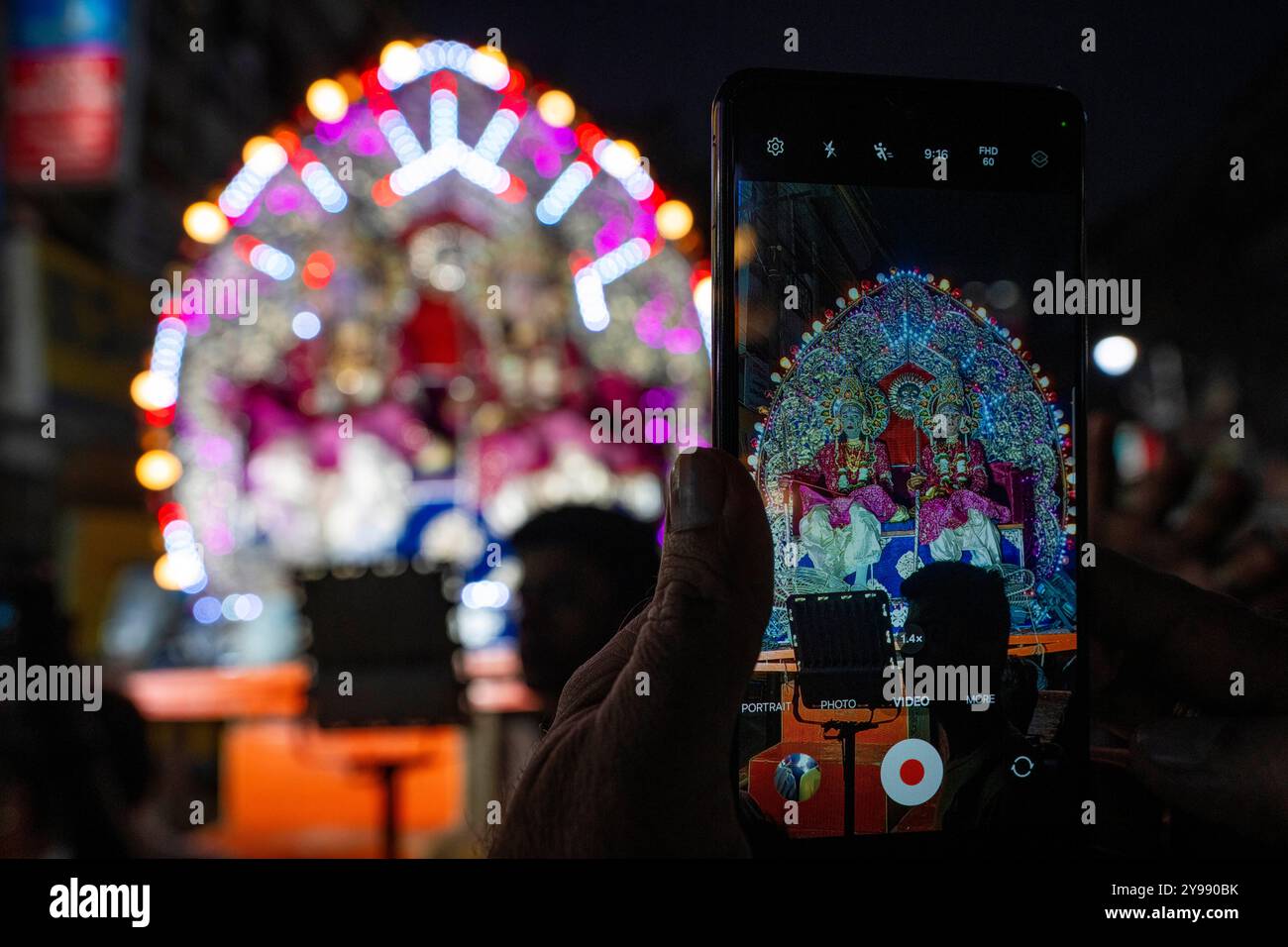 A person takes a snap of Indian artists dressed as Hindu deities Rama ...