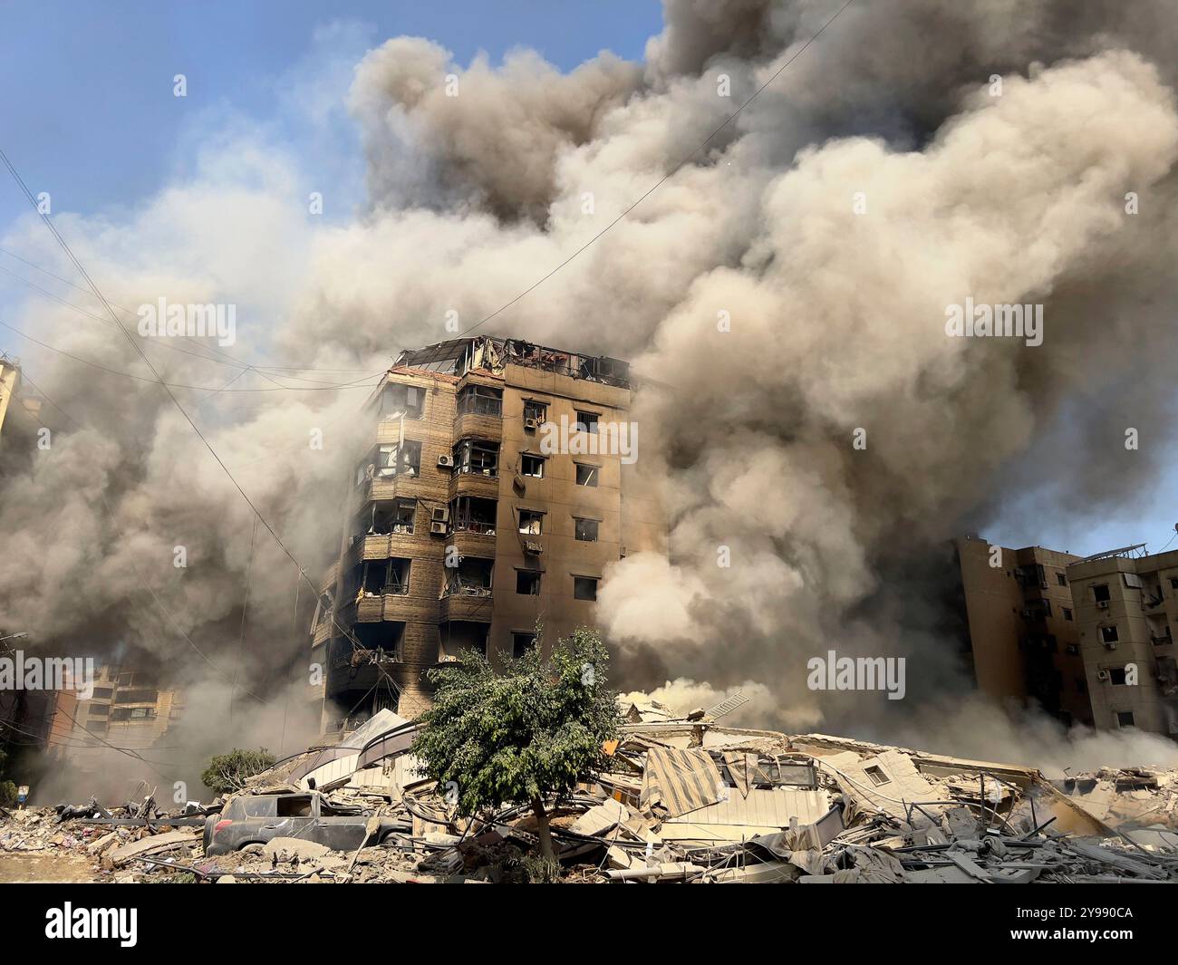 FILE - Smoke rises as a building collapses in Beirut's southern suburbs ...