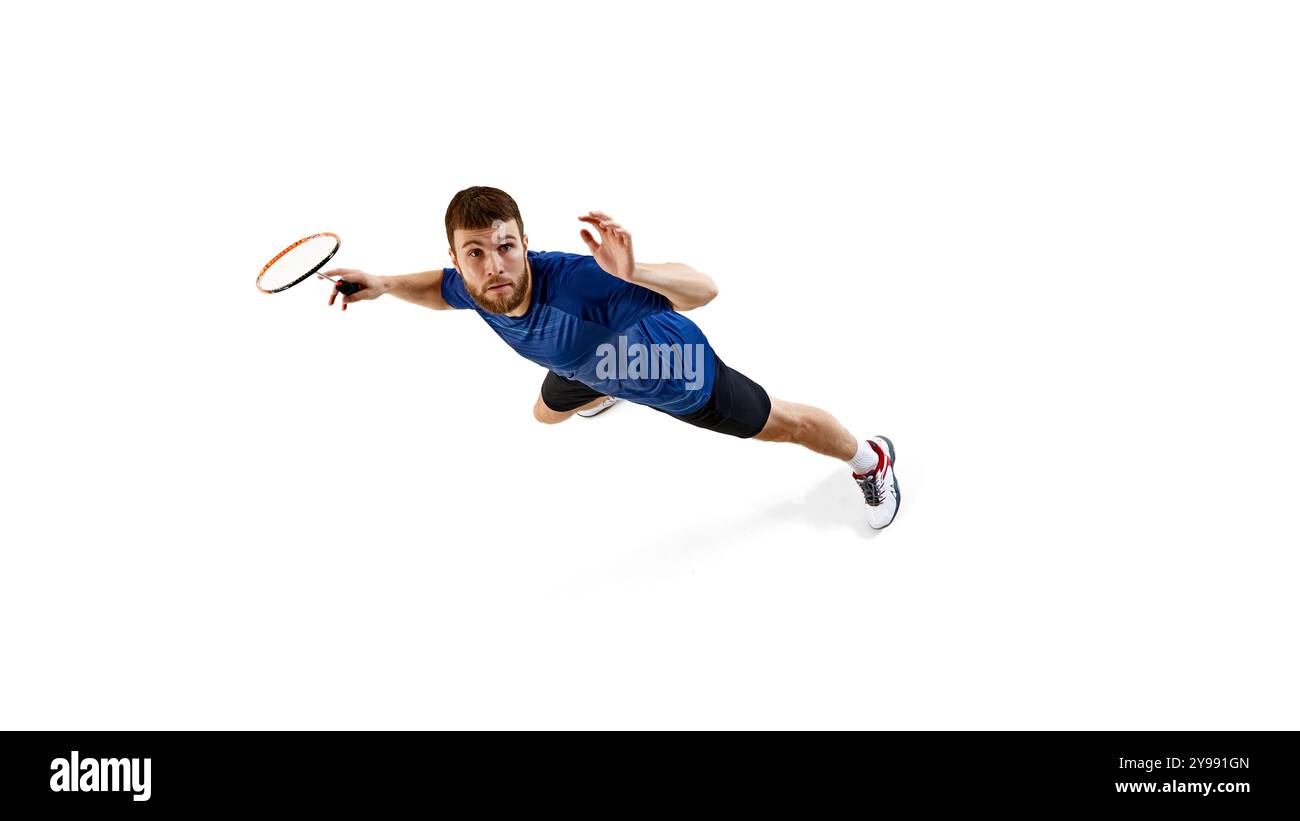 Energetic badminton player in full jump, swinging his racket with force ...