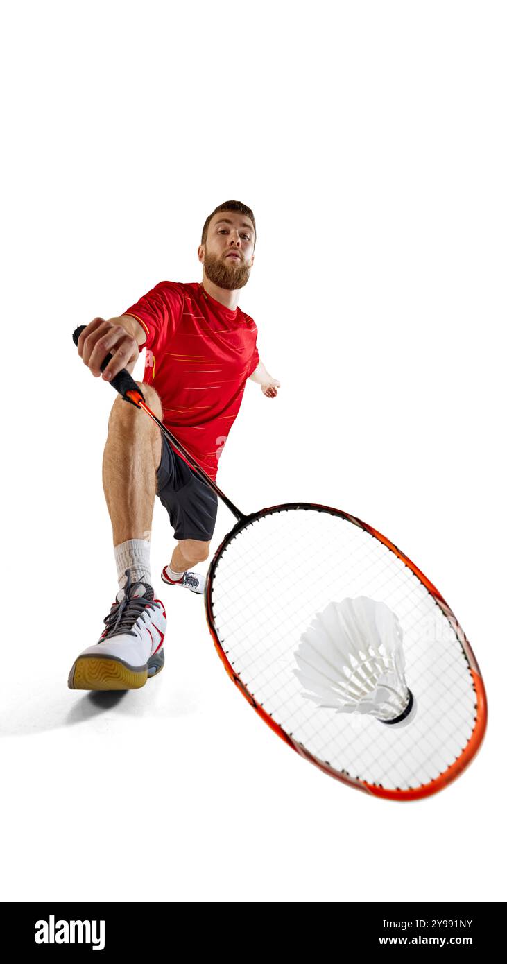 Low shot of badminton player stepping forward, swinging racket ...