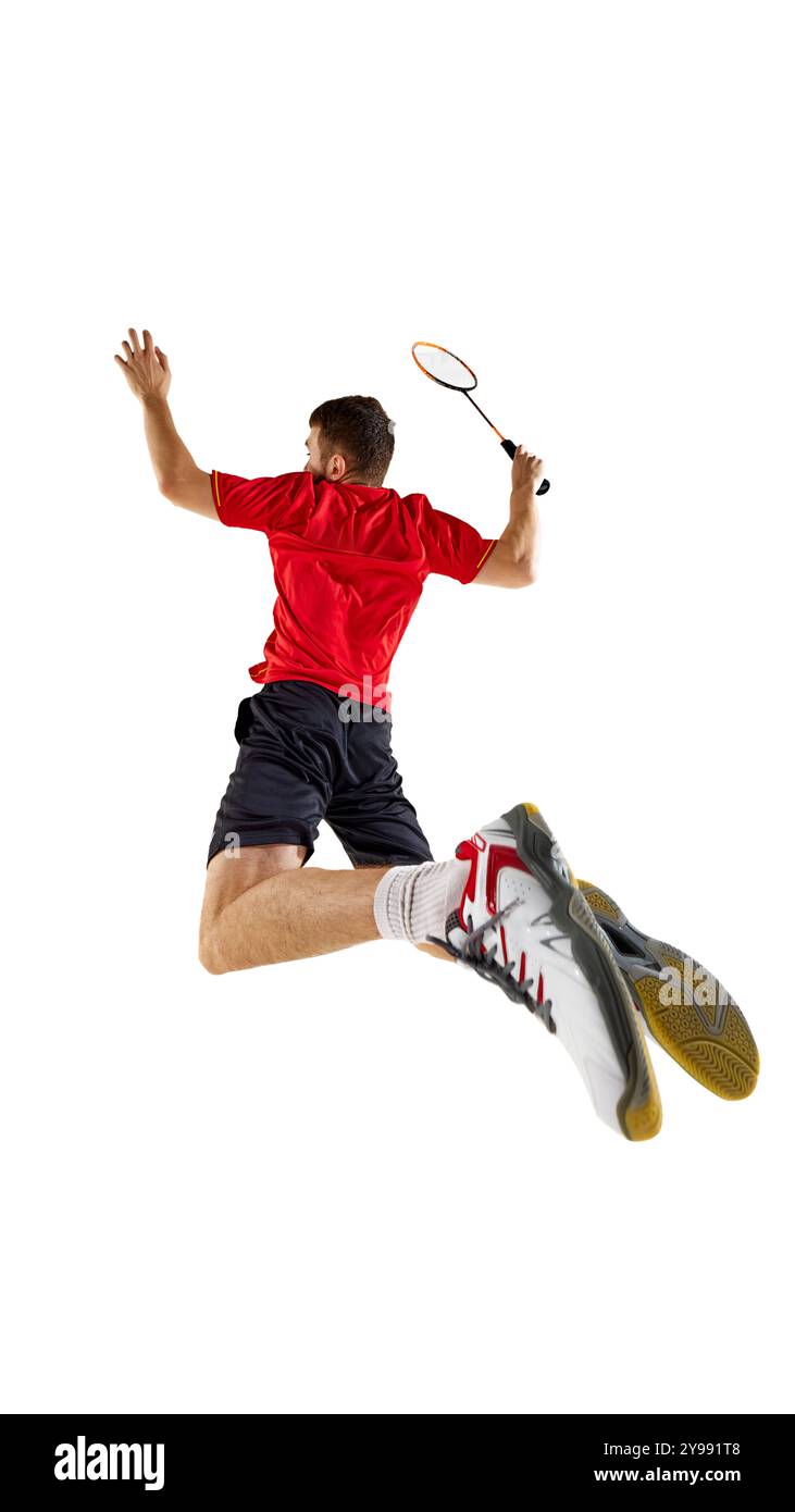 Rear view photo of powerful jump shot in badminton as the athlete leaps ...