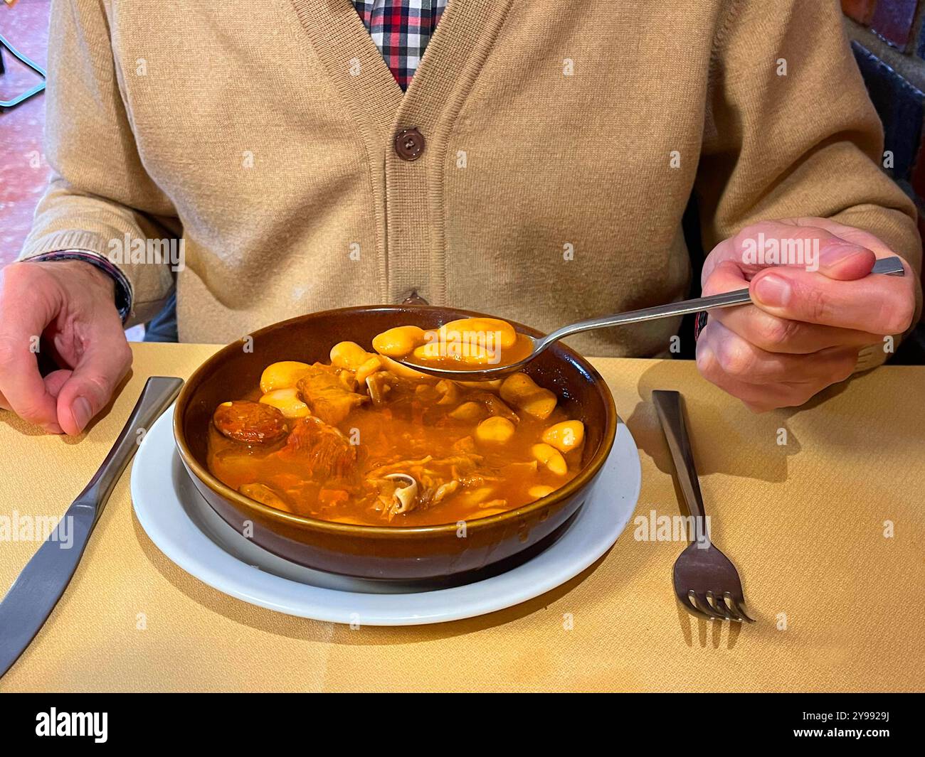 Man eating beans stew Stock Photo - Alamy