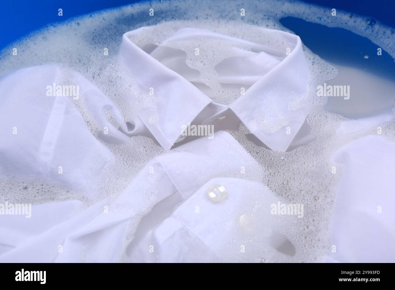 White shirt in suds, closeup. Hand washing laundry Stock Photo - Alamy