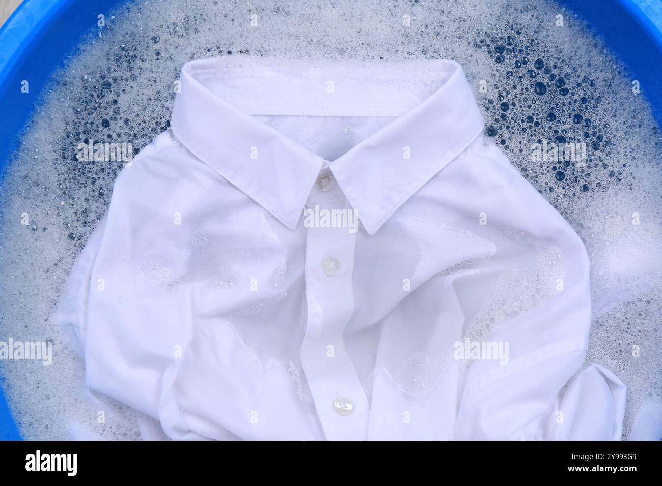 White shirt in suds, closeup. Hand washing laundry Stock Photo - Alamy