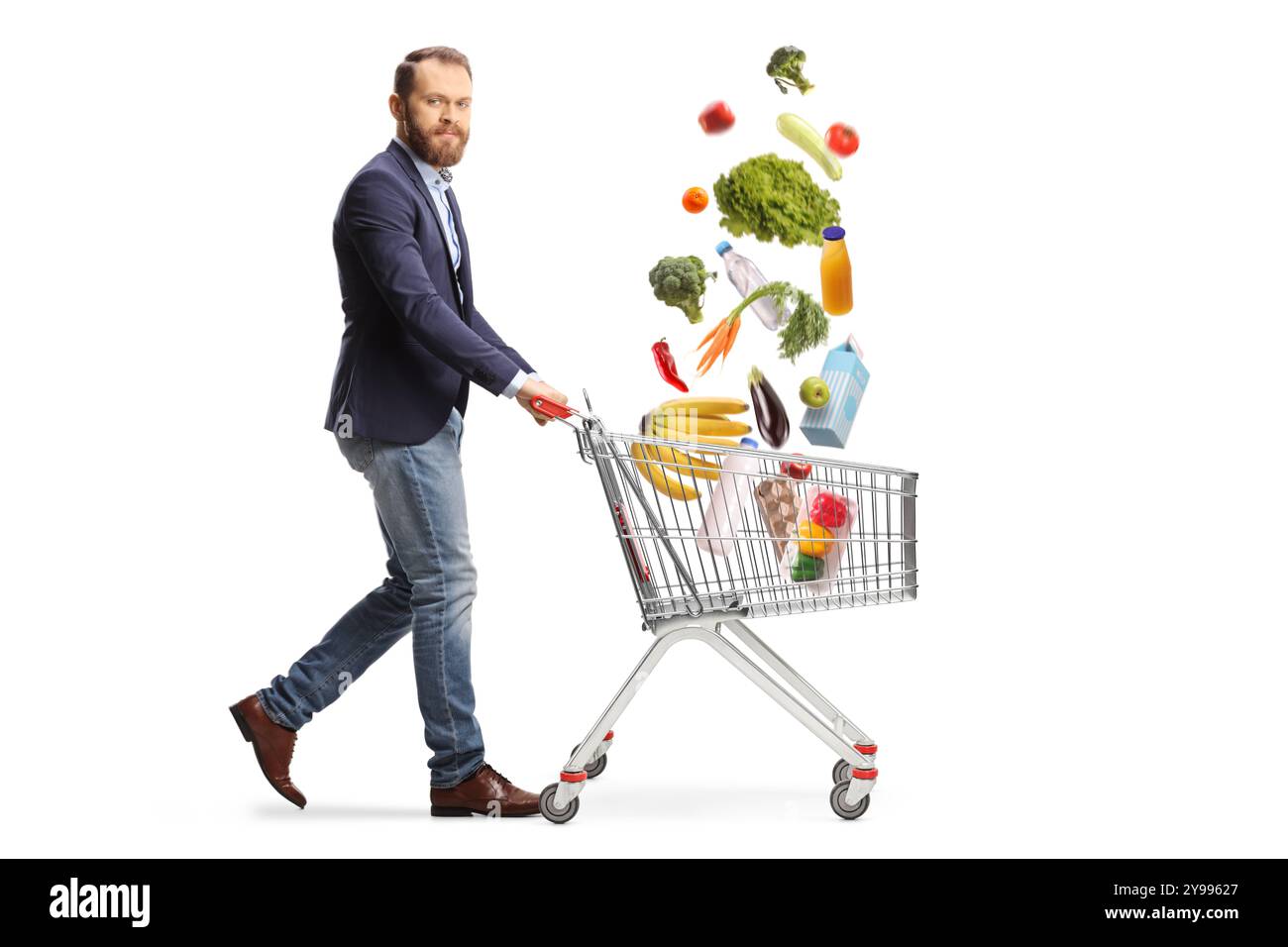 Bearded guy walking and pushing a shopping cart with groceries falling ...