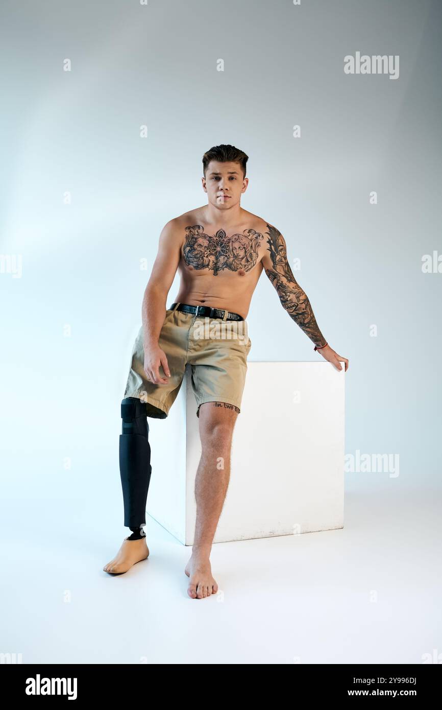 A young man with striking tattoos showcases his prosthetic leg while ...