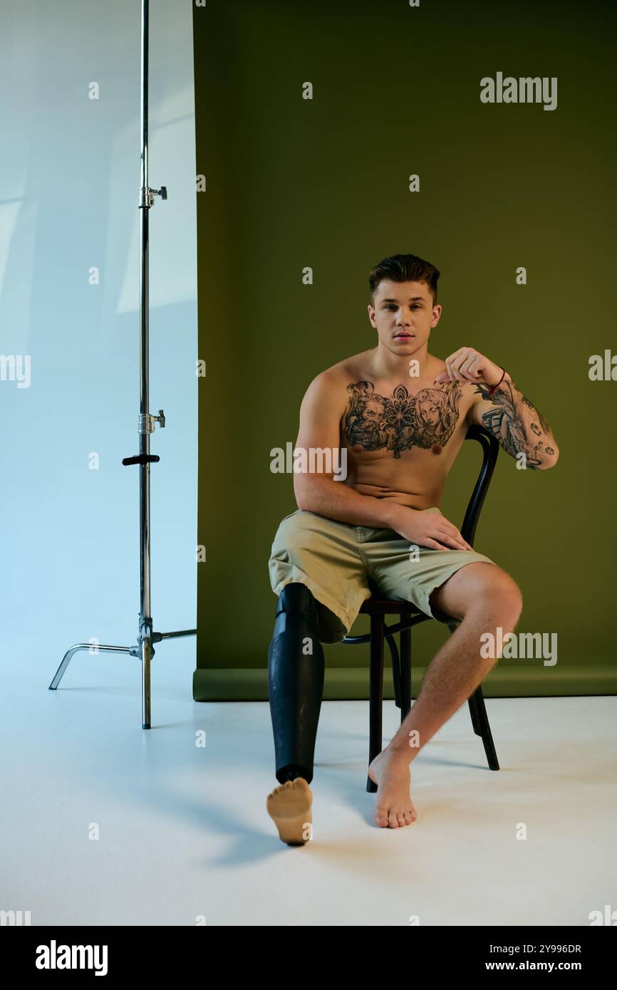 A tattooed young man showcases his prosthetic leg while sitting ...