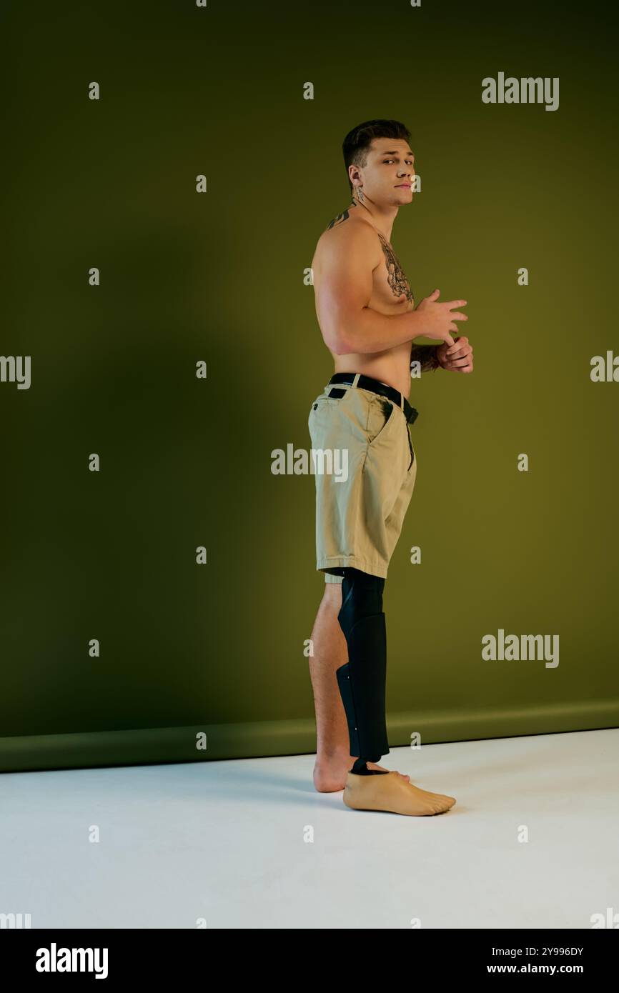 A tattooed young man confidently showcases his prosthetic leg while ...