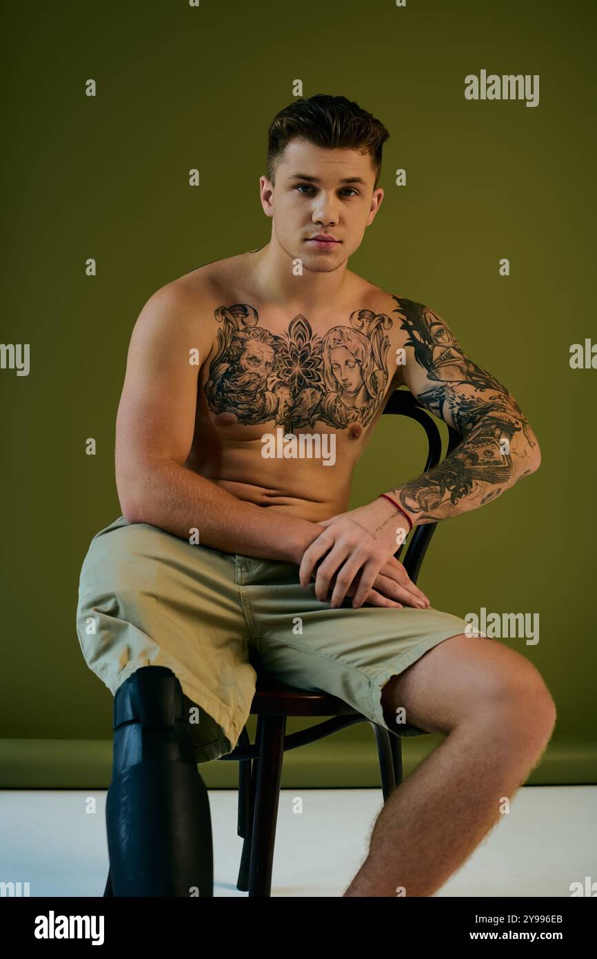 A young man with striking tattoos sits gracefully in a studio ...