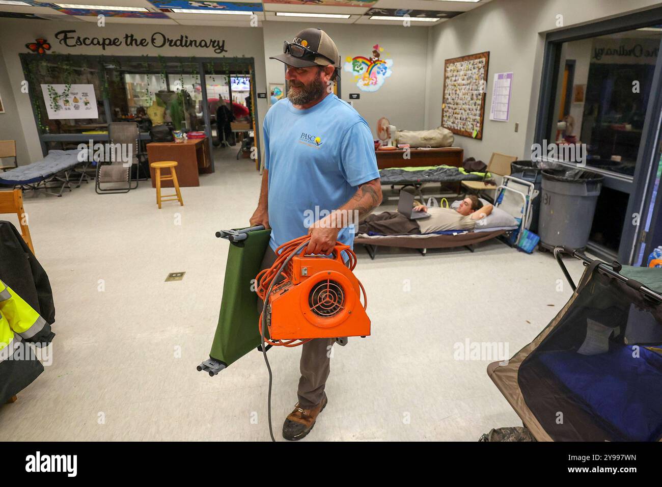 Mike Ketchum brings in equipment to set up for sleeping in a classroom ...