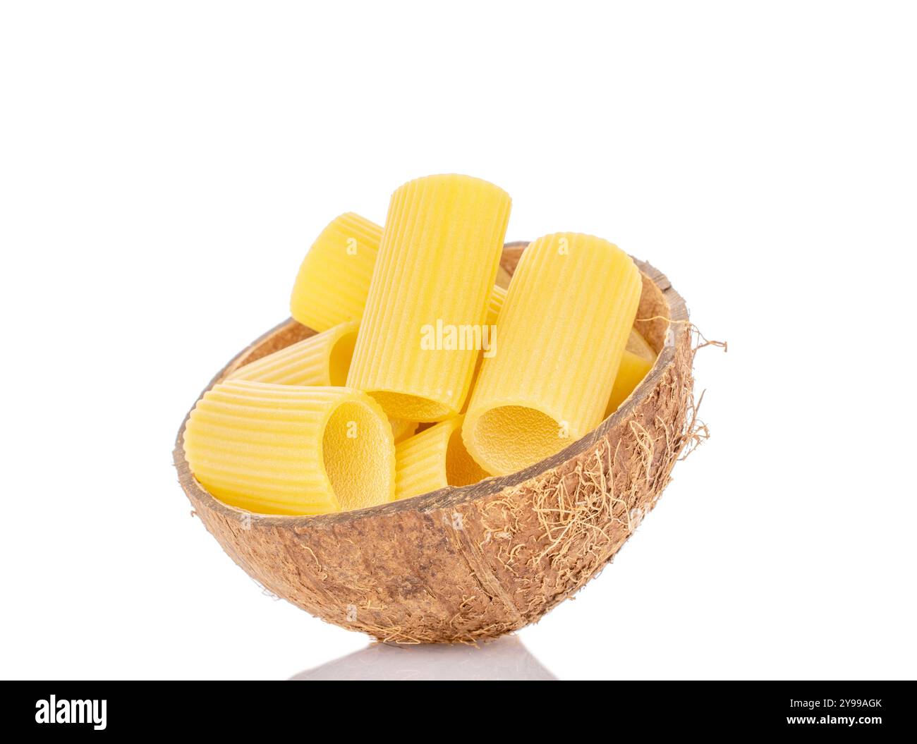 Raw durum wheat cannelloni pasta in coconut shell, macro, isolated on ...