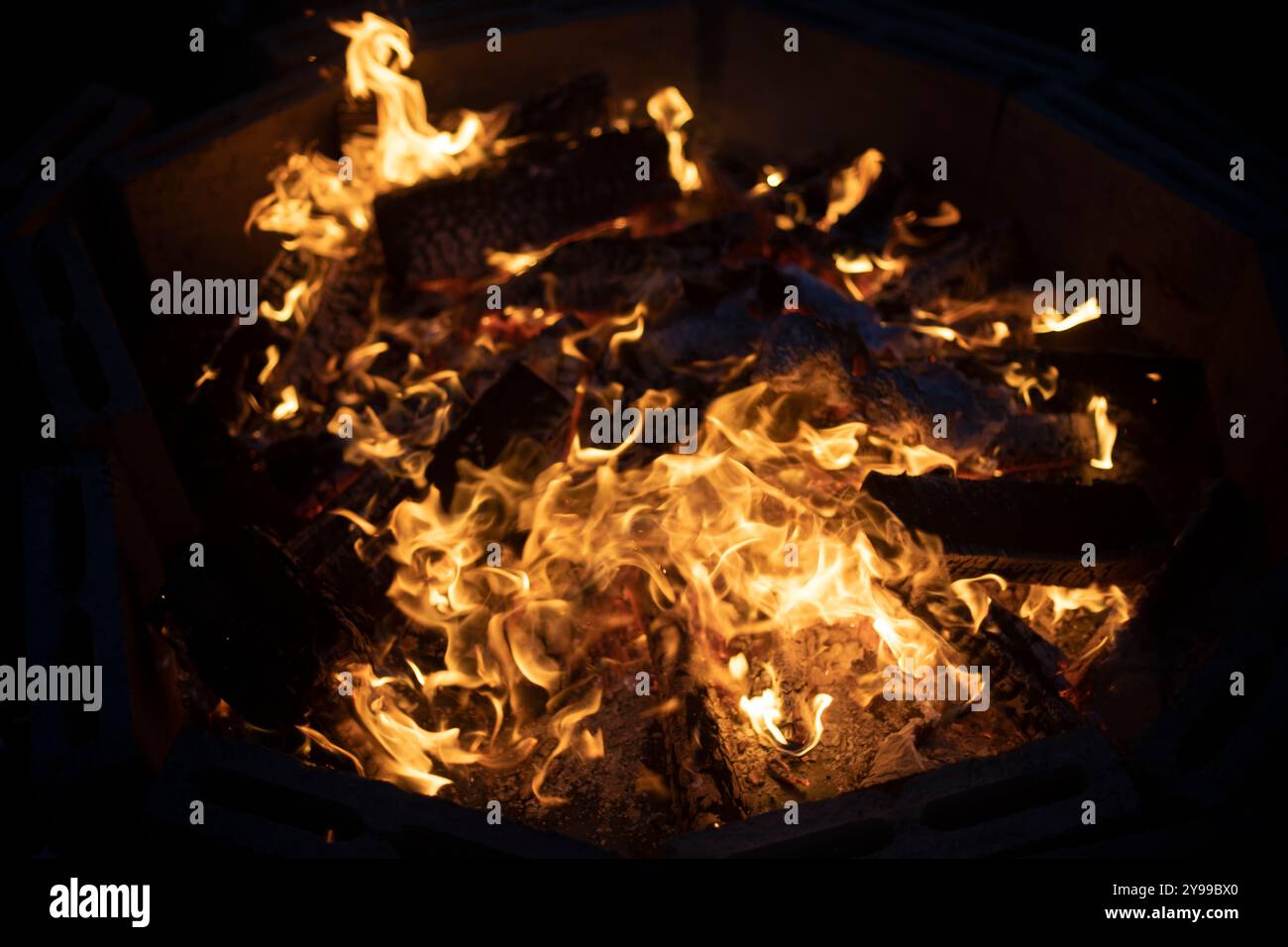 Big bonfire at night. Firewood burns in open air. Yellow flame. High ...