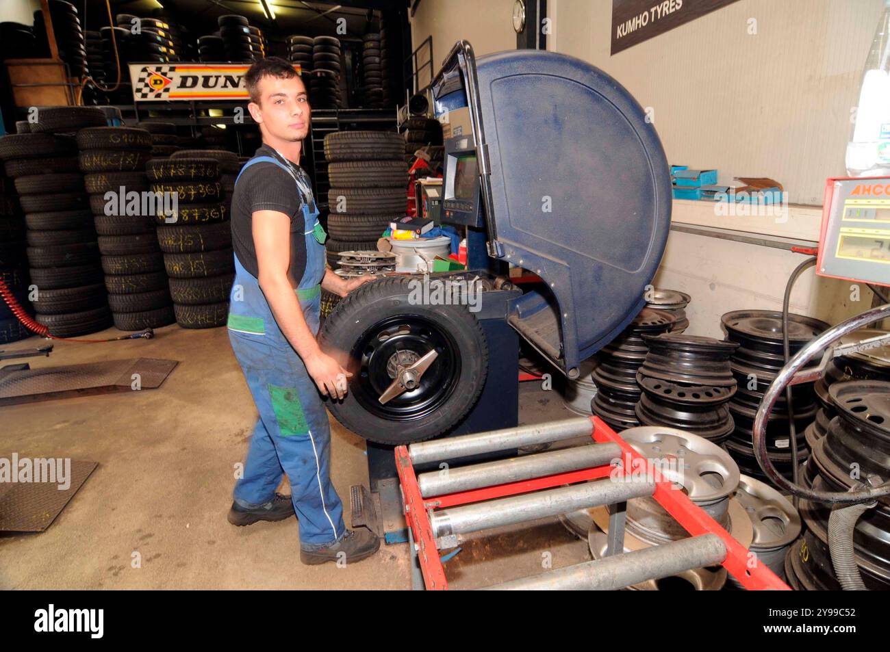 RECORD DATE NOT STATED employee at the car shop manually changing tire ...