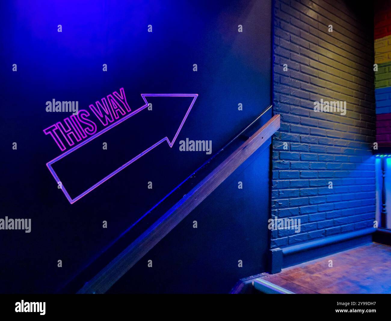 This way neon sign at colorful room and rainbow colors on the wall ...