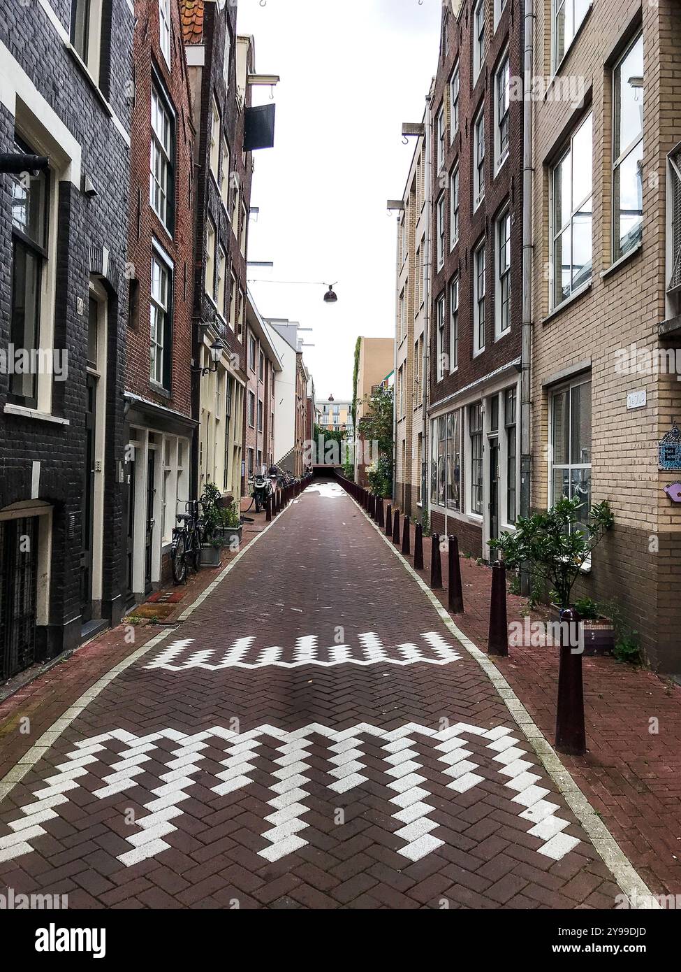 A narrow alley in between Dutch traditional buildings in Amsterdam ...