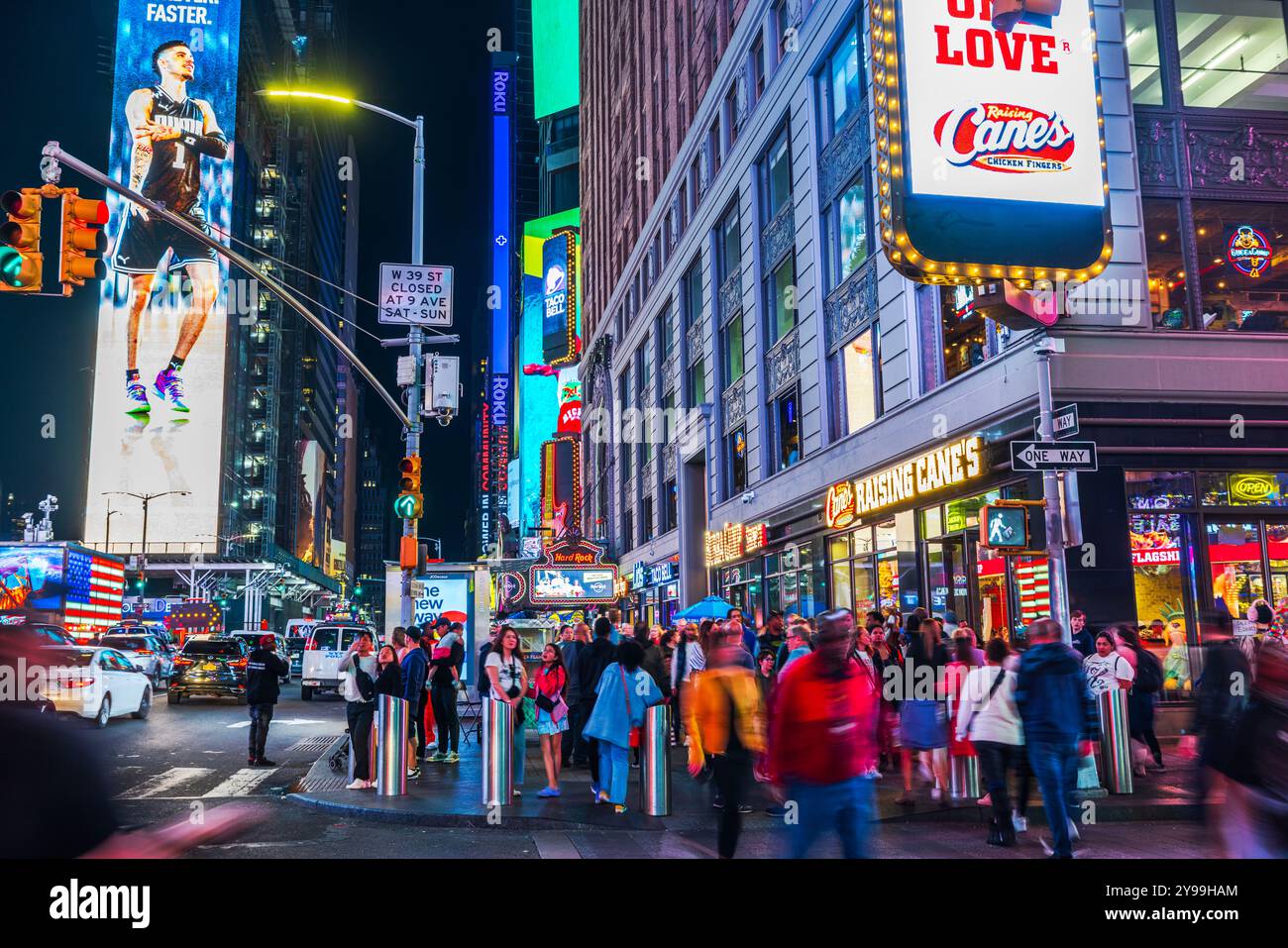 Busy Times Square street at night with Raising Cane's, Hard Rock Cafe ...