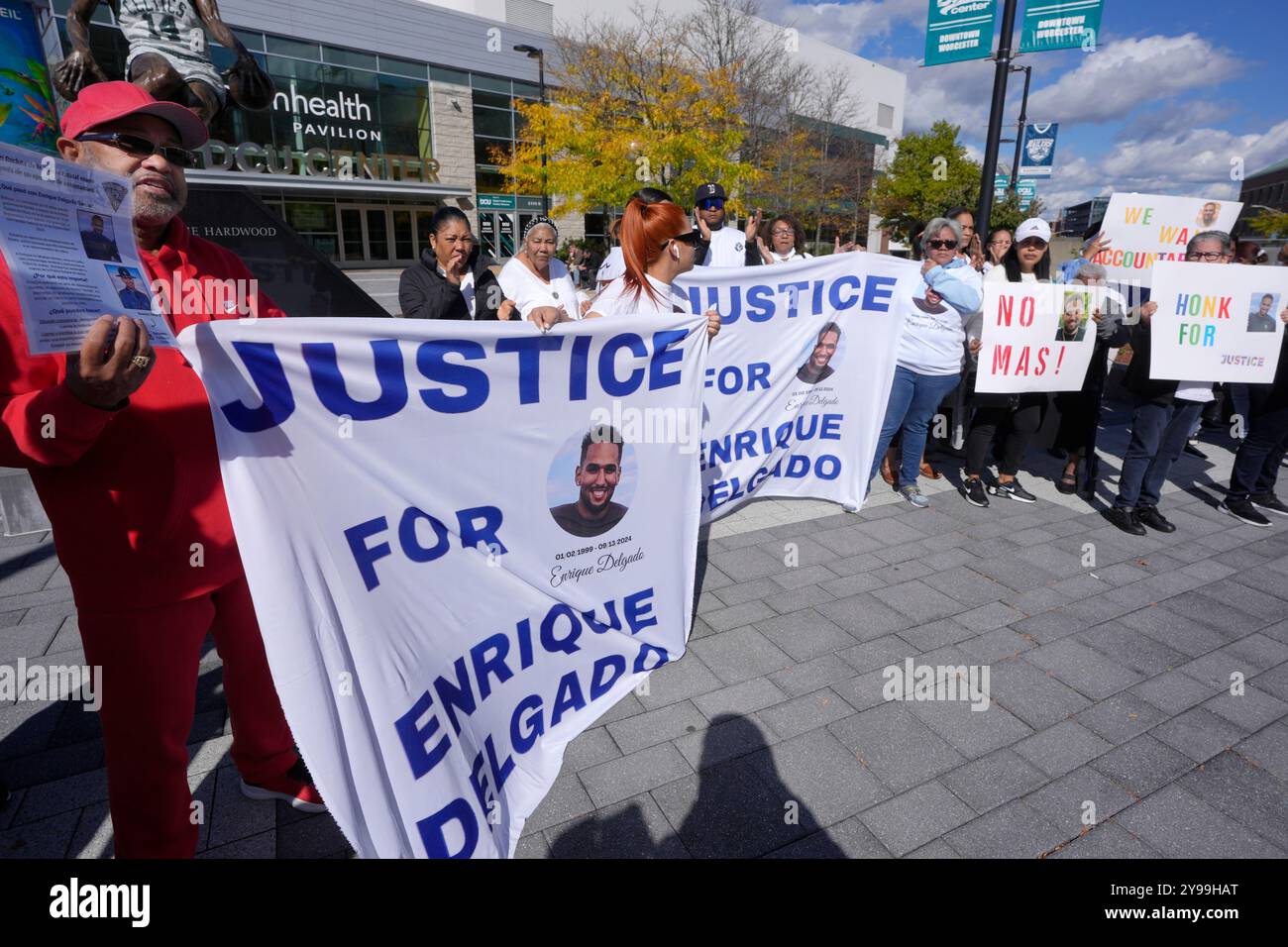 People display signs with with a likeness of Massachusetts State Police recruit Enrique Delgado ...