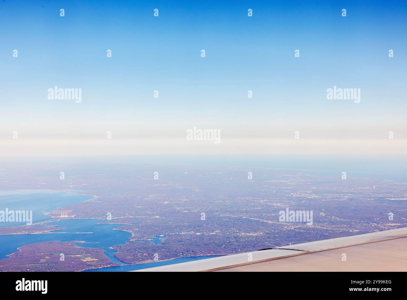 Aerial view of coastline and land from plane window during takeoff ...