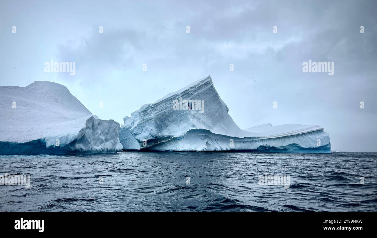 A massive iceberg drifts through the stormy waters of the Southern ...
