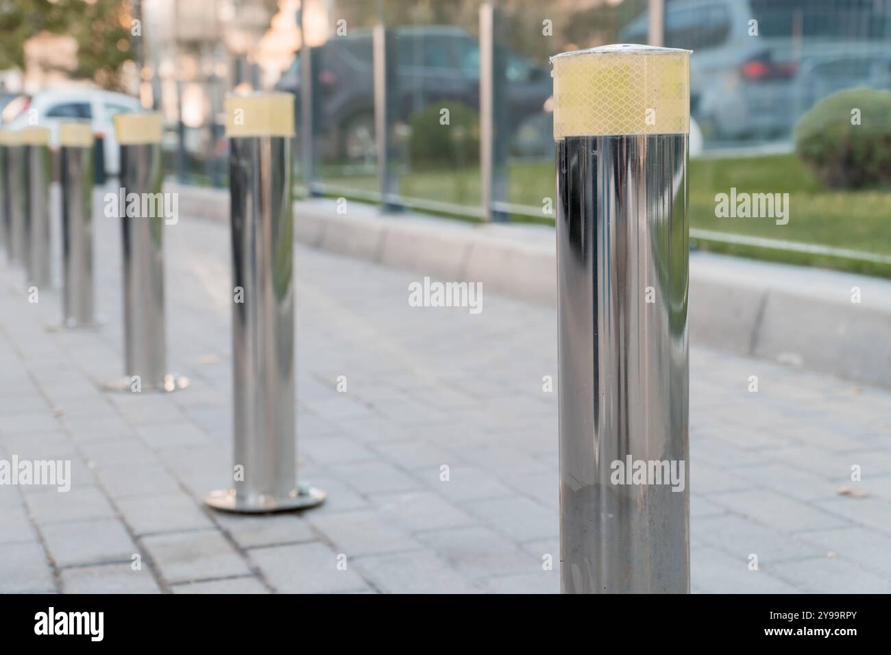 Polished Stainless Steel Bollards Emerging Elegantly from a City Sidewalk Stock Photo - Alamy