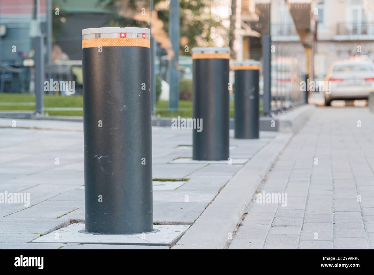 Urban Streetscape Featuring Modern Black Bollards with Amber Trim in a ...