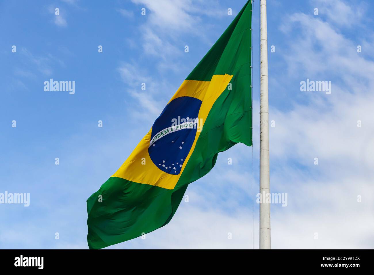 Flag of Brazil, country located in South America, on a blue sky between ...
