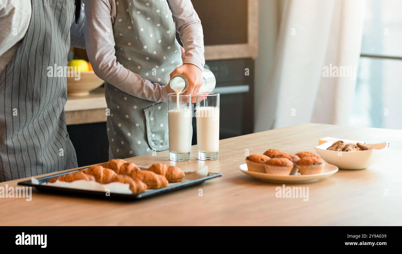 Little Girl Having Snacks With Dad In Kitchen, Pouring Milk To Glasses ...