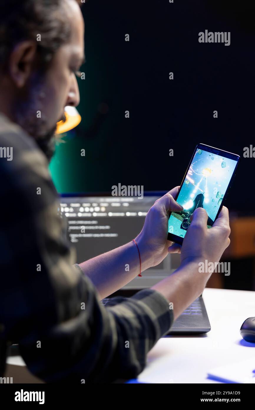 Male individual playing competitive video game on cell phone. Man is ...