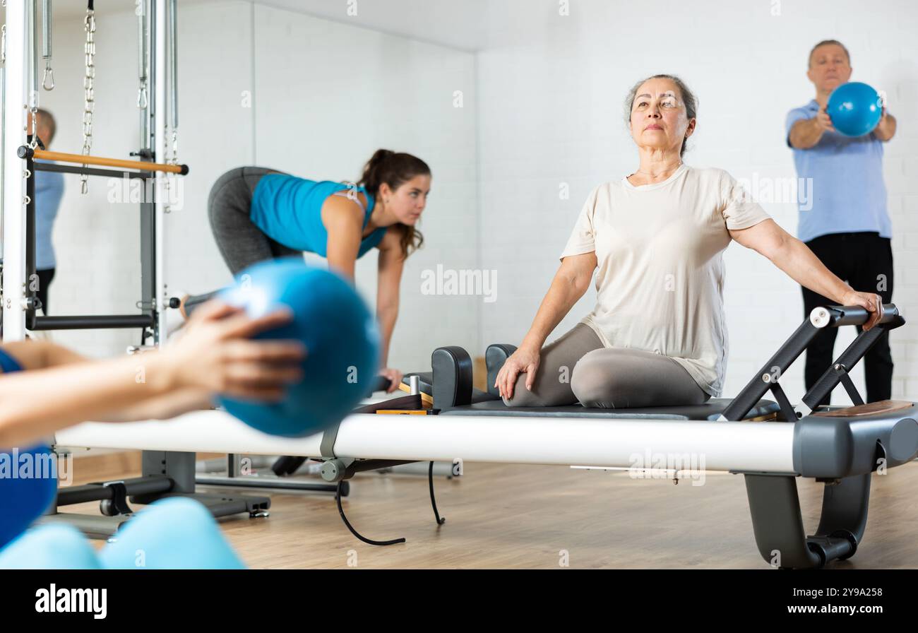 Senior woman doing stretching exercises on pilates reformer Stock Photo ...