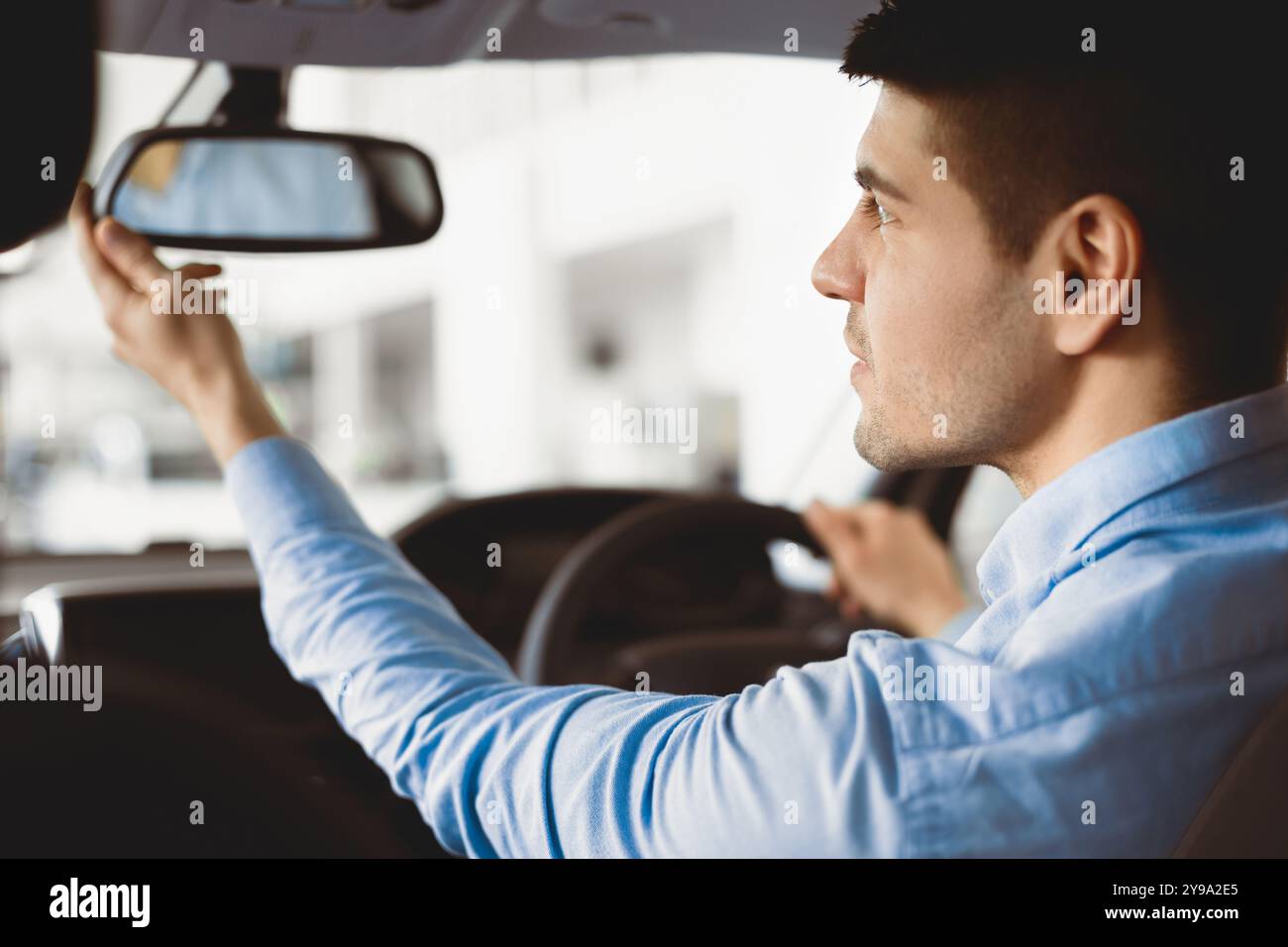 Guy Checking Mirrors Sitting In Driver's Seat Stock Photo - Alamy