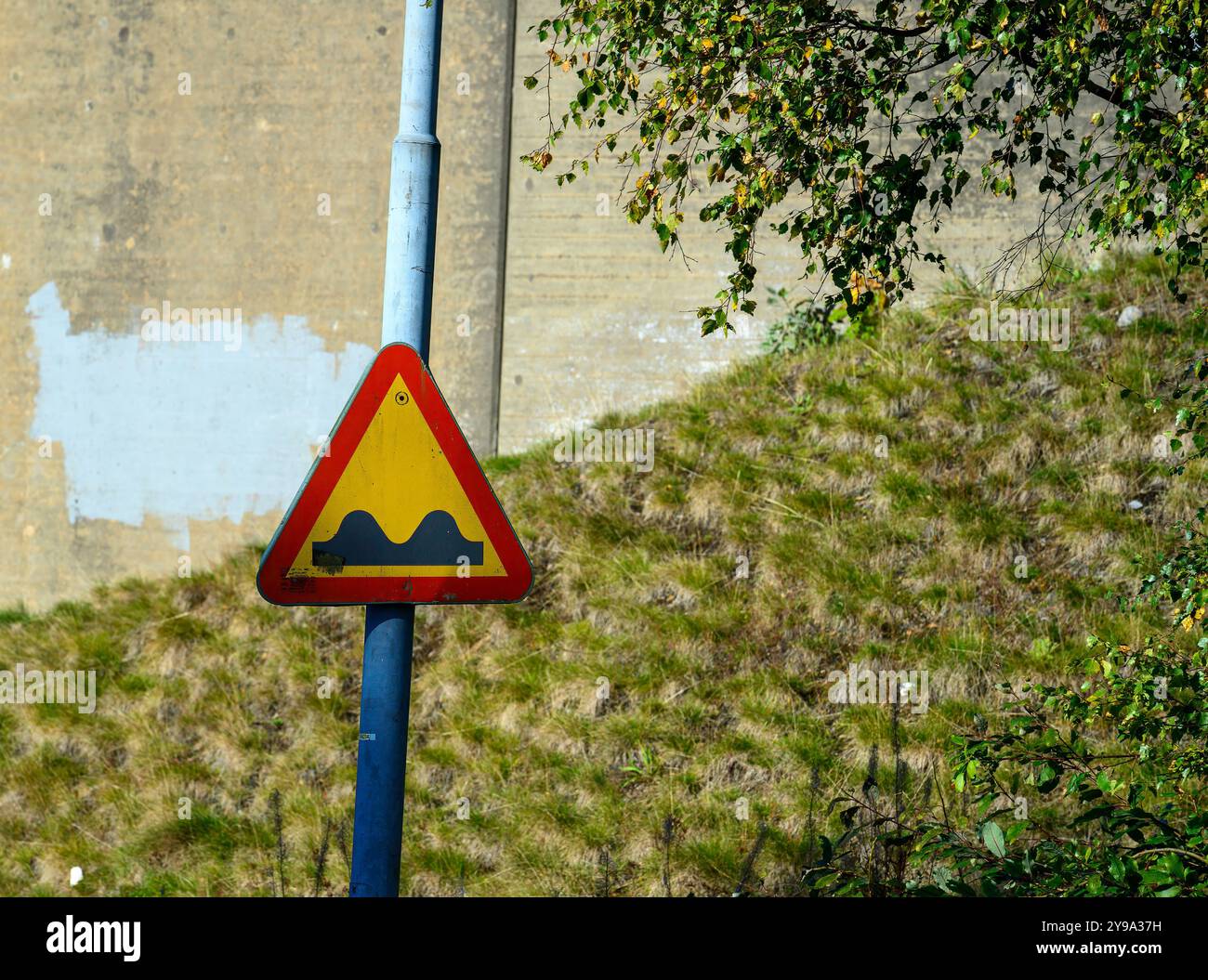 A triangular warning sign alerts drivers to bumps ahead, positioned ...