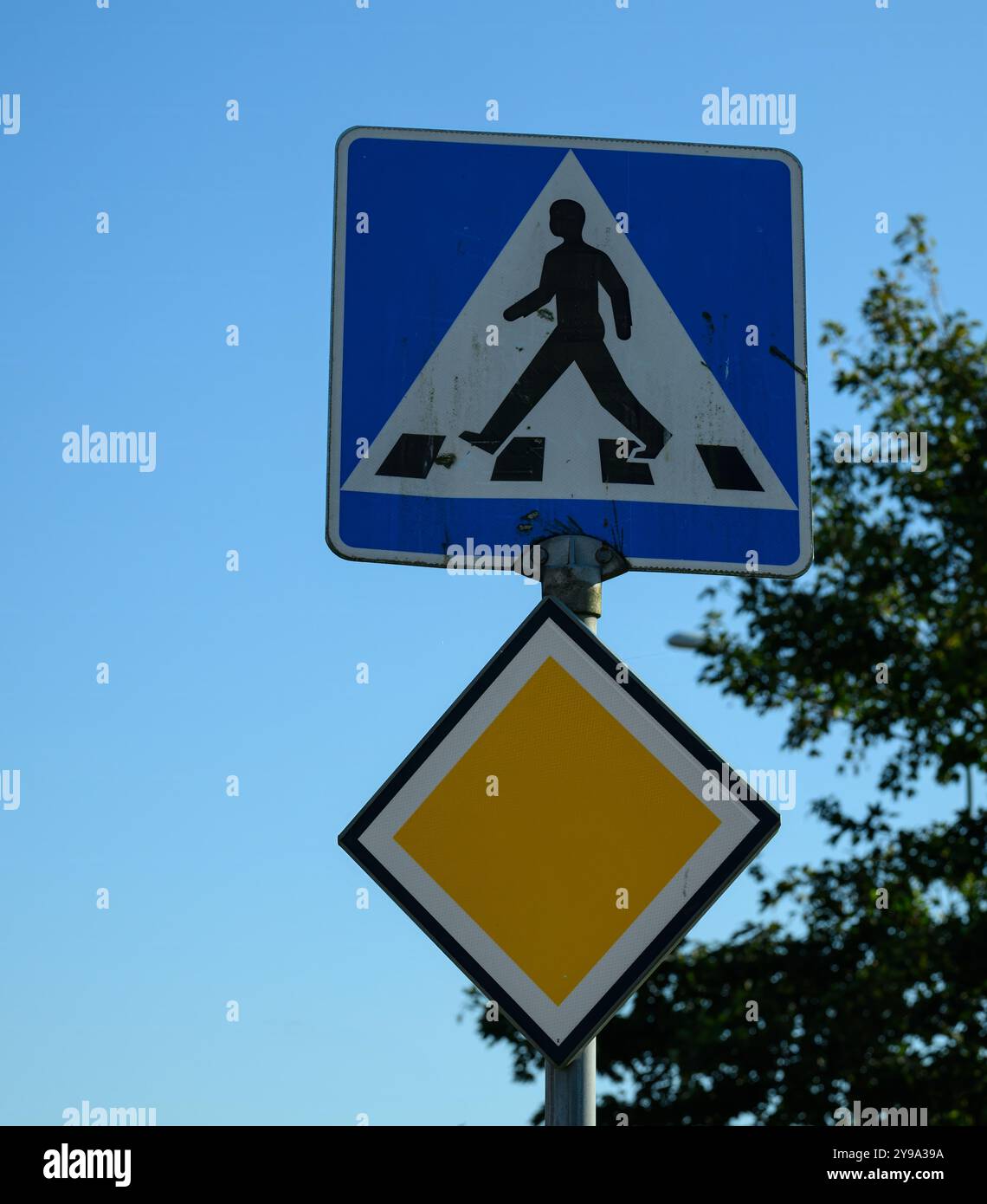 The sign shows a walking figure on a striped crosswalk, emphasizing ...