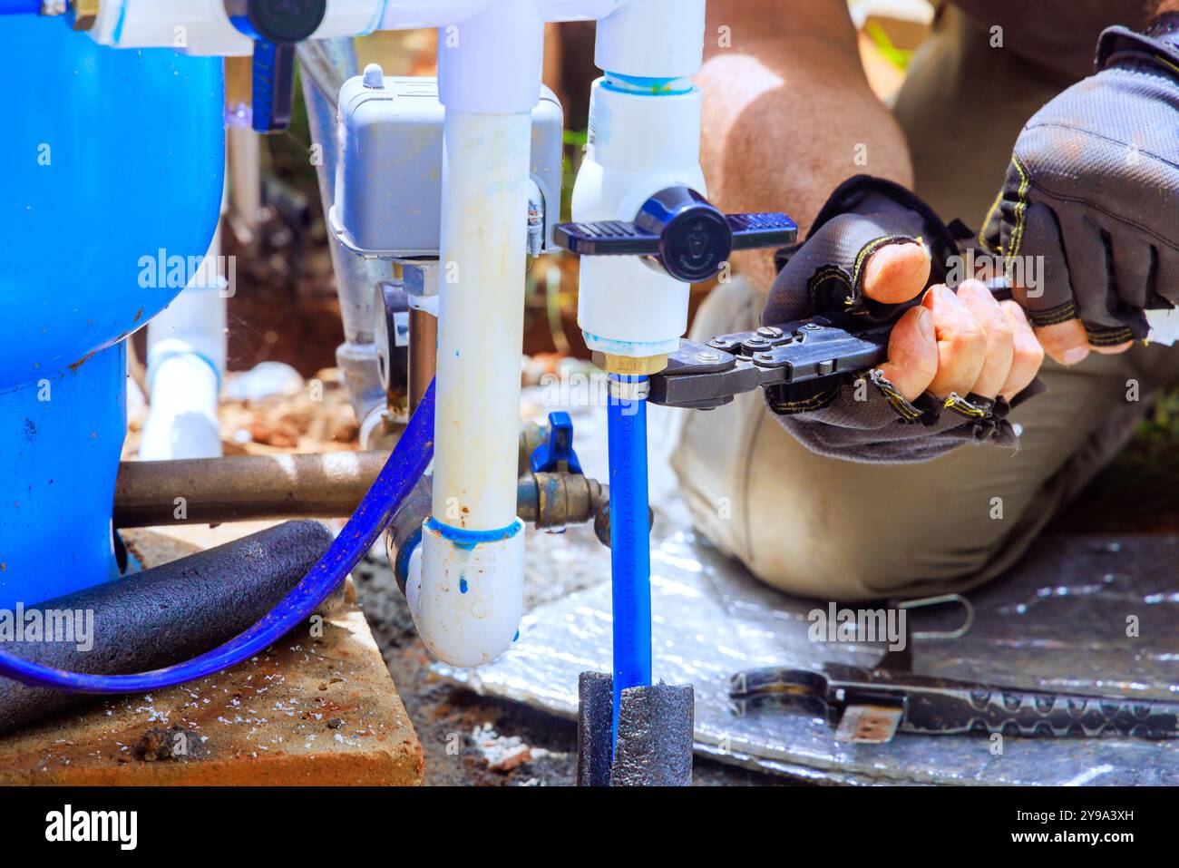 Plumber assembles connection of water well to water system at house ...