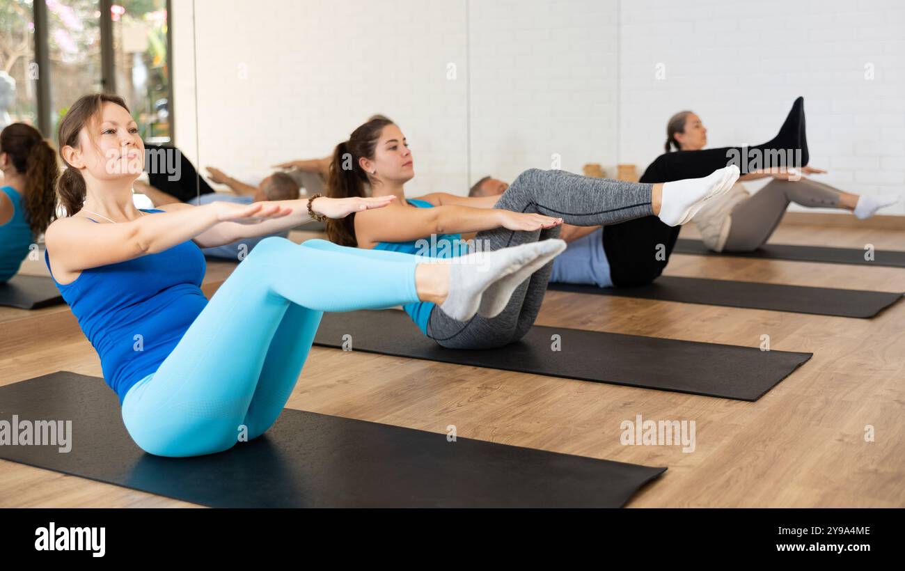 Young woman doing v-sit during warming up in pilates studio Stock Photo ...