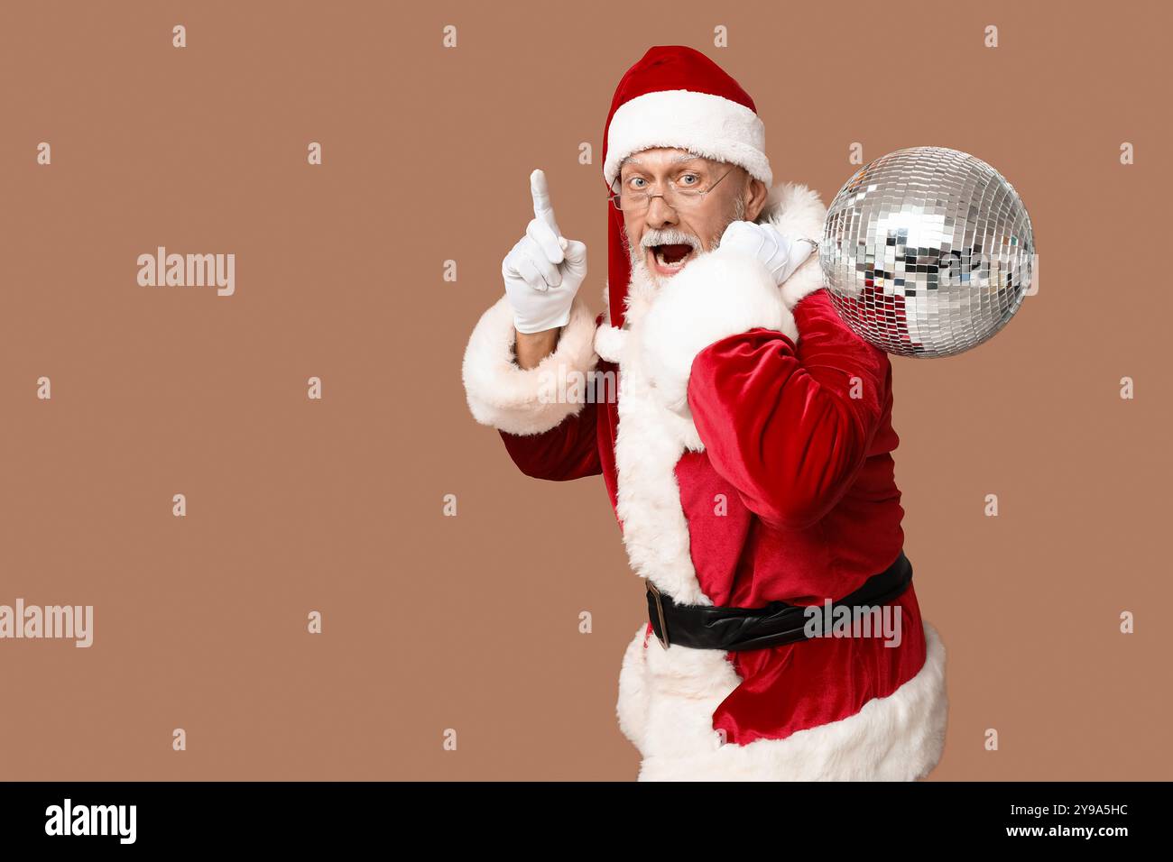 Shocked Santa Claus in glasses with disco ball pointing at something on ...