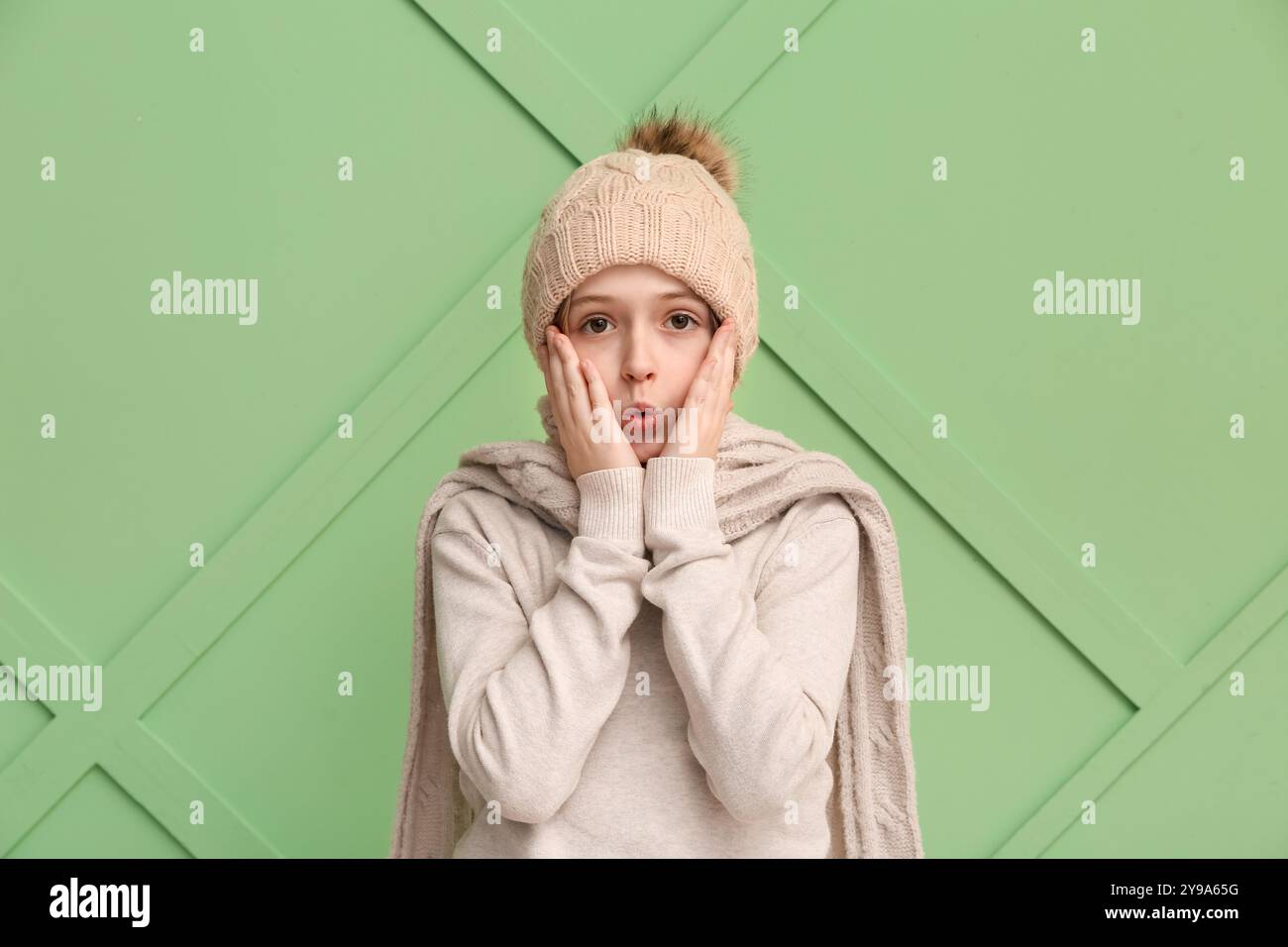 Cute little shocked boy in winter clothes on green background Stock ...