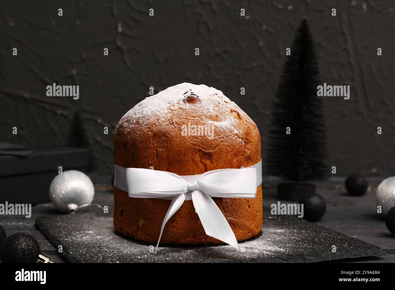 Panettone sprinkled with powdered sugar on black background Stock Photo ...