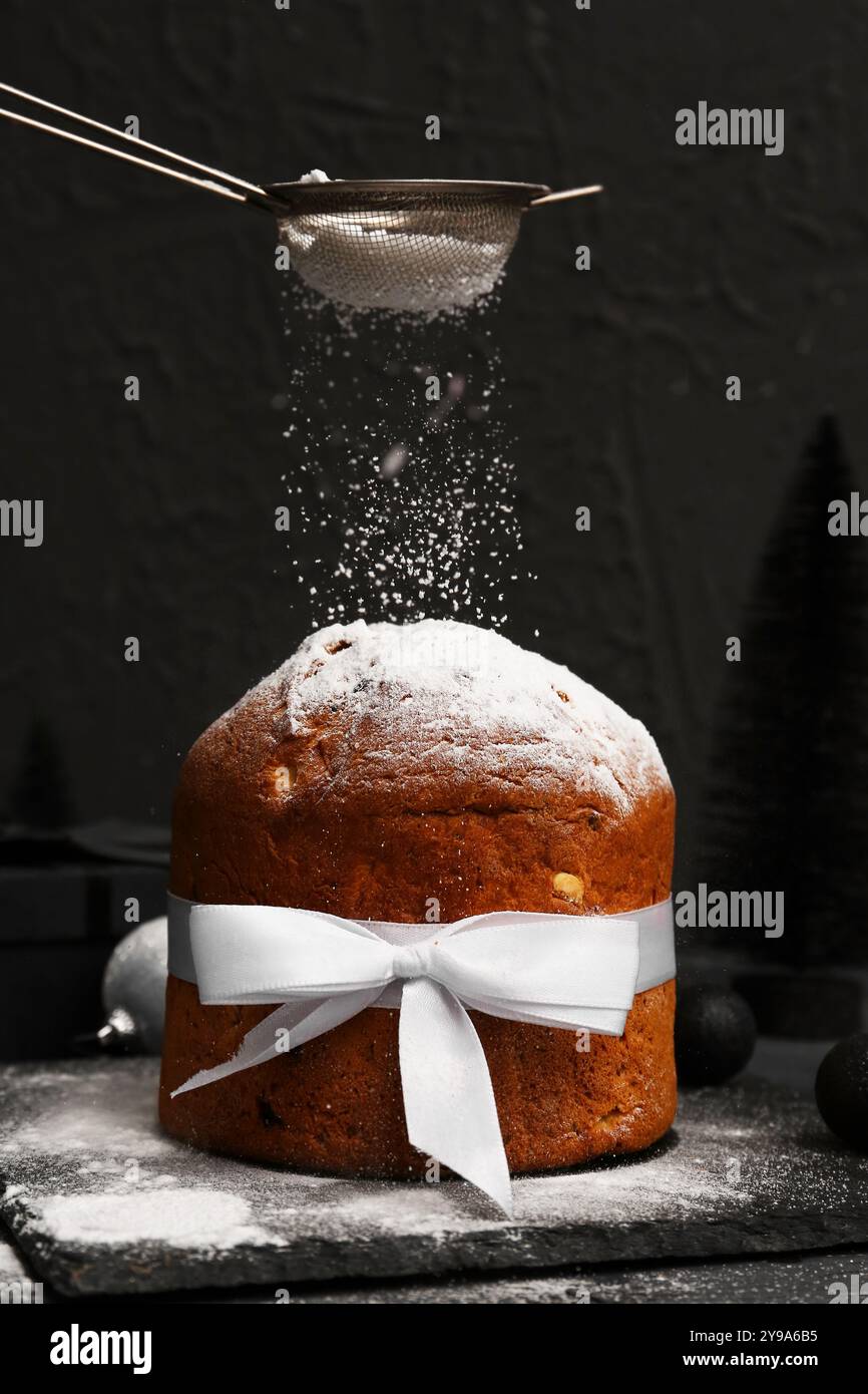 Panettone sprinkled with powdered sugar on black background Stock Photo ...