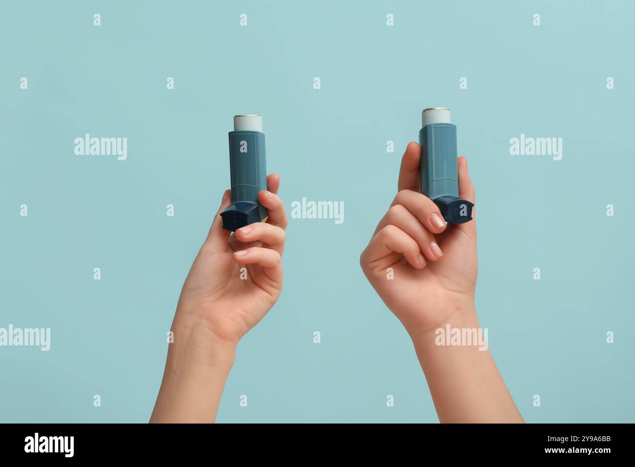 Female hands with modern asthma inhalers on blue background Stock Photo ...