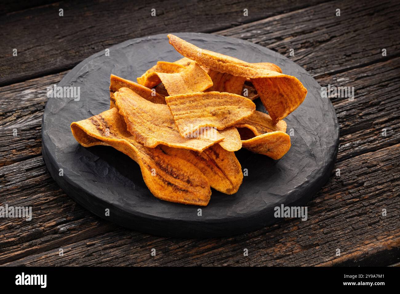 Sliced fried ripe plantain - Patacones on the plate. Musa x paradisiaca ...