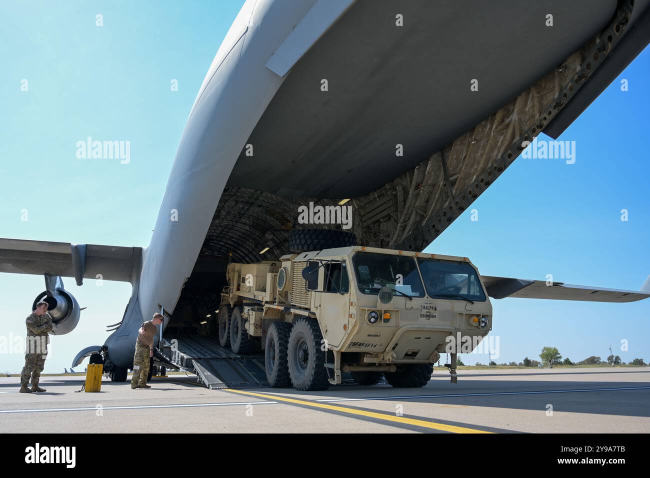 A Heavy Expanded Mobility Tactical Truck (HEMTT) backs into a C-17 ...