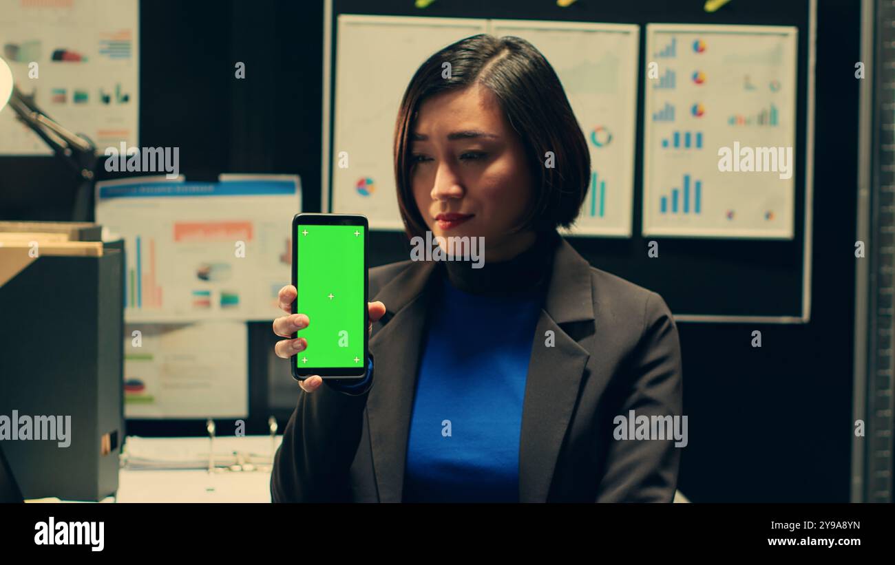 Investigator showing greenscreen layout on smartphone display, working ...