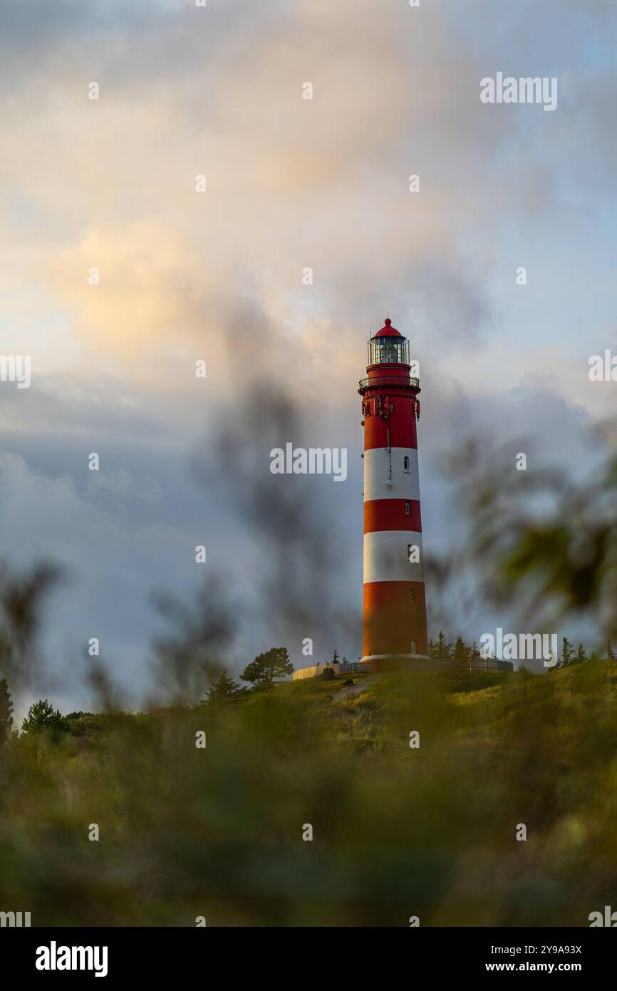 A striking lighthouse with red and white stripes stands proudly on a ...